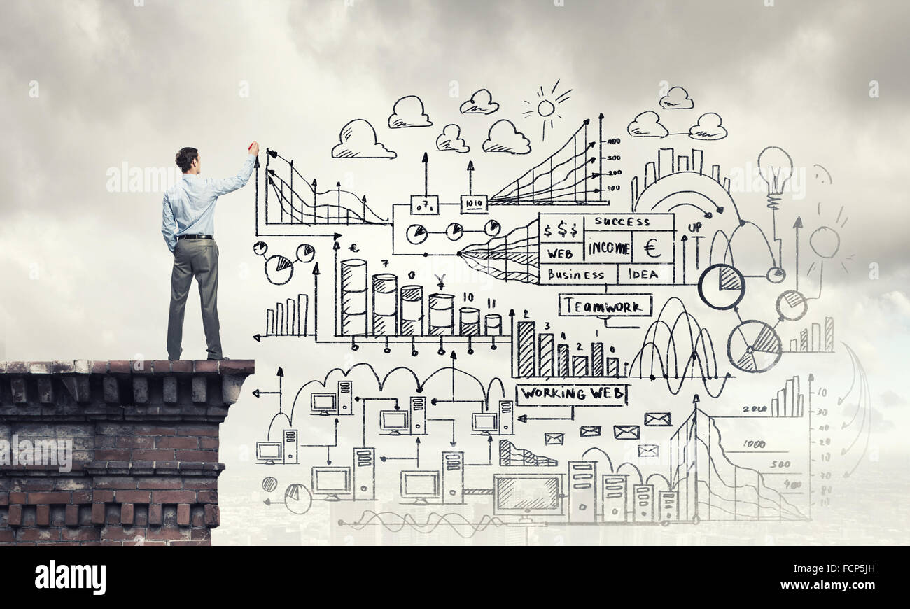 Back view of businessman drawing business sketches on wall Stock Photo ...