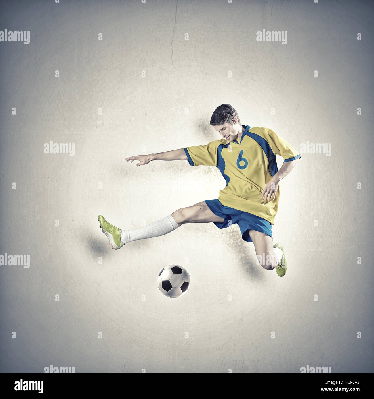 Handsome male football player jumping to hit the ball Stock Photo - Alamy