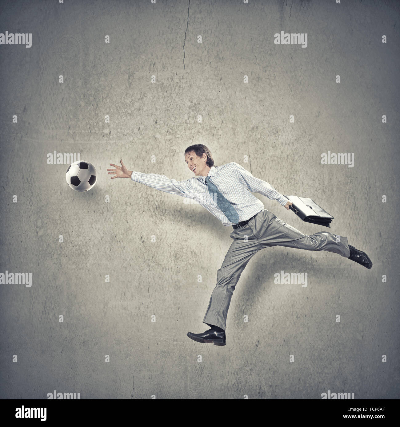 Businessman in suit jumping to hit soccer ball hi-res stock photography ...