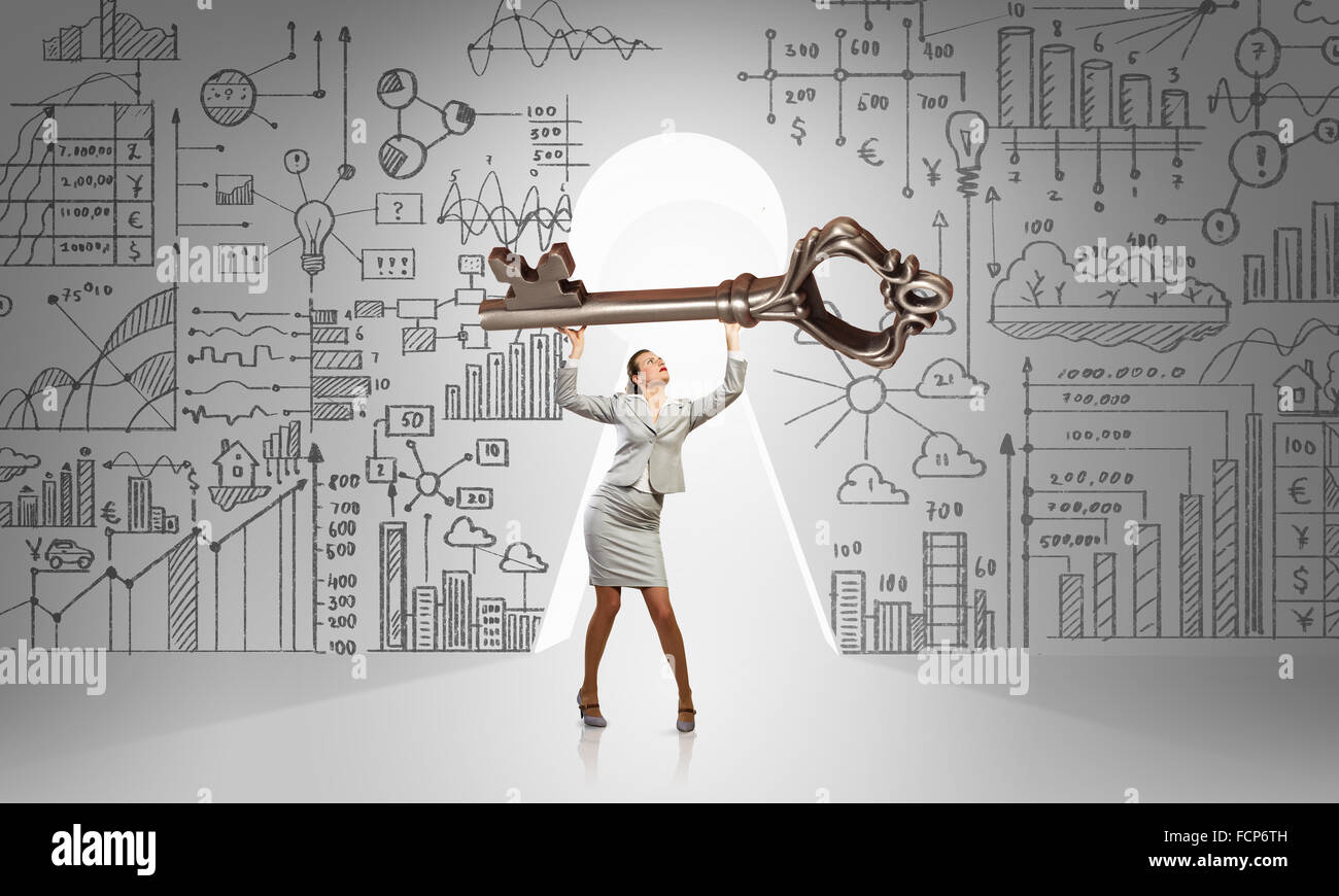 Young businesswoman and keyhole at background lifting big key above ...