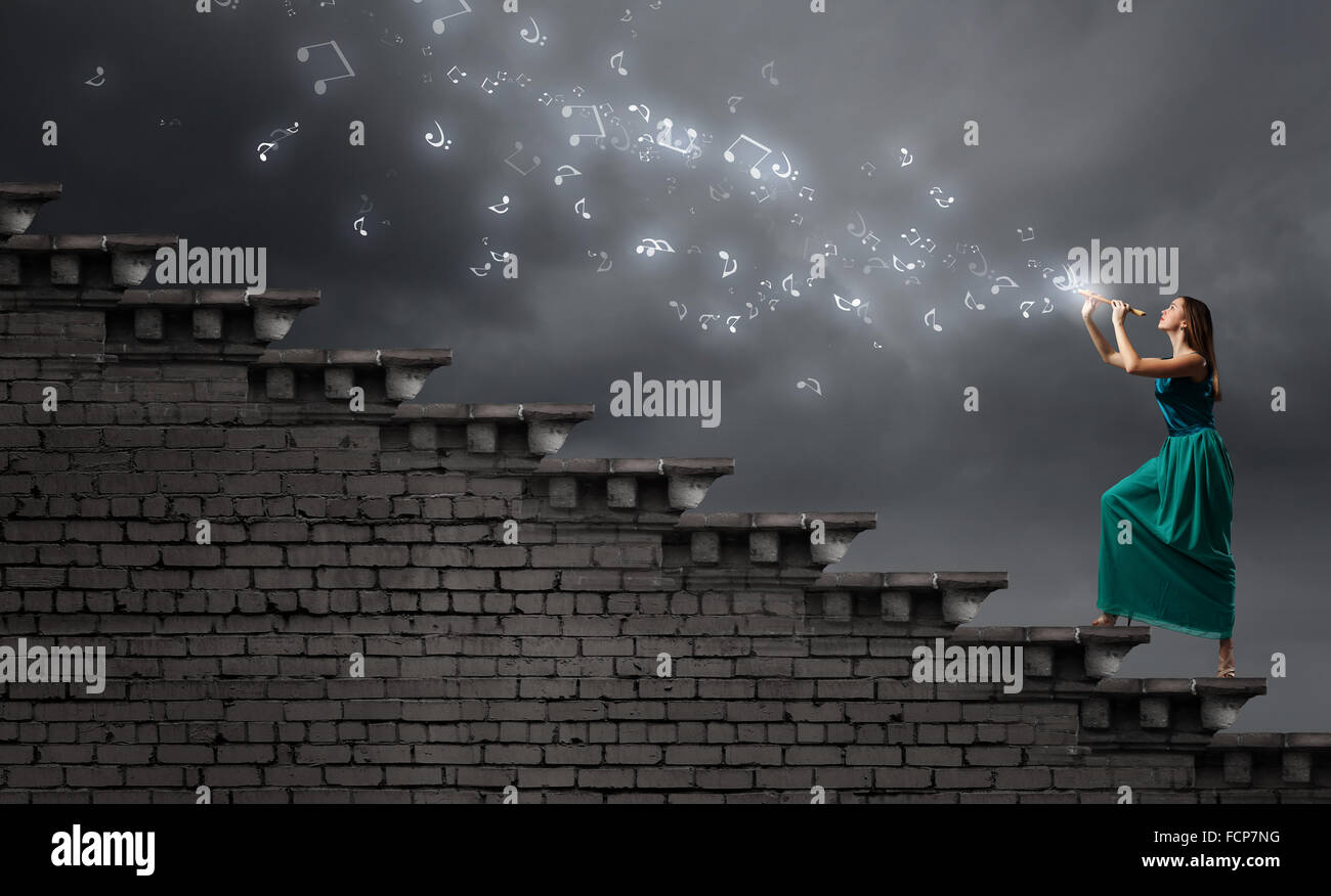 Young pretty woman in green long gress playing fife Stock Photo - Alamy