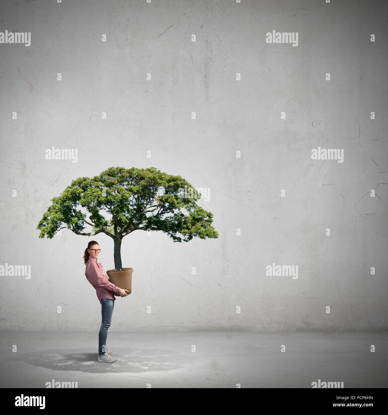 Young girl student carrying green tree in pot Stock Photo - Alamy