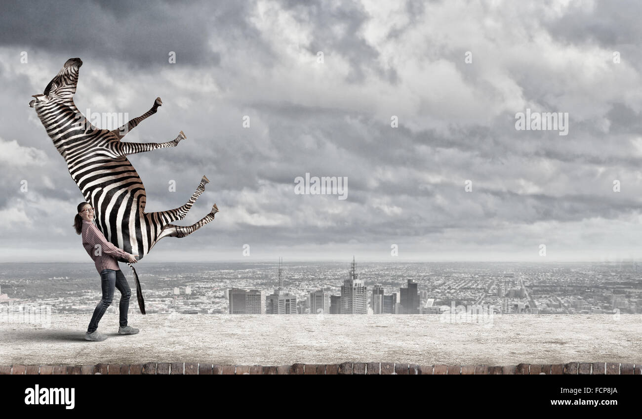 Funny young girl holding zebra animal in hands Stock Photo - Alamy