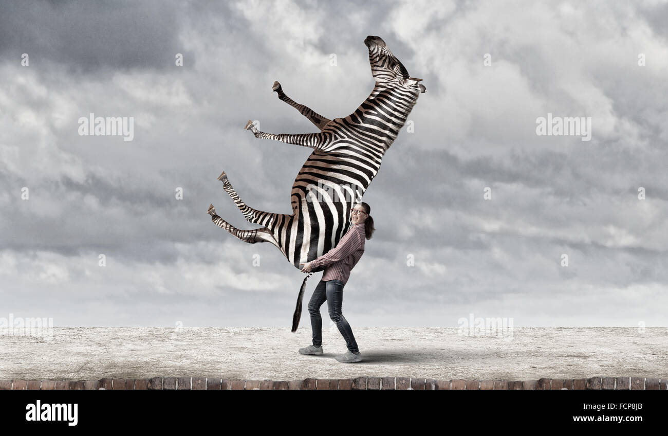 Funny young girl holding zebra animal in hands Stock Photo - Alamy