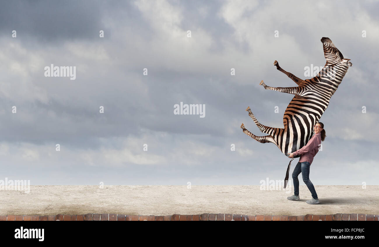 Funny young girl holding zebra animal in hands Stock Photo - Alamy