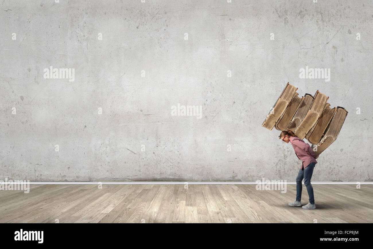 Young student girl lifting pile of old books on back Stock Photo - Alamy