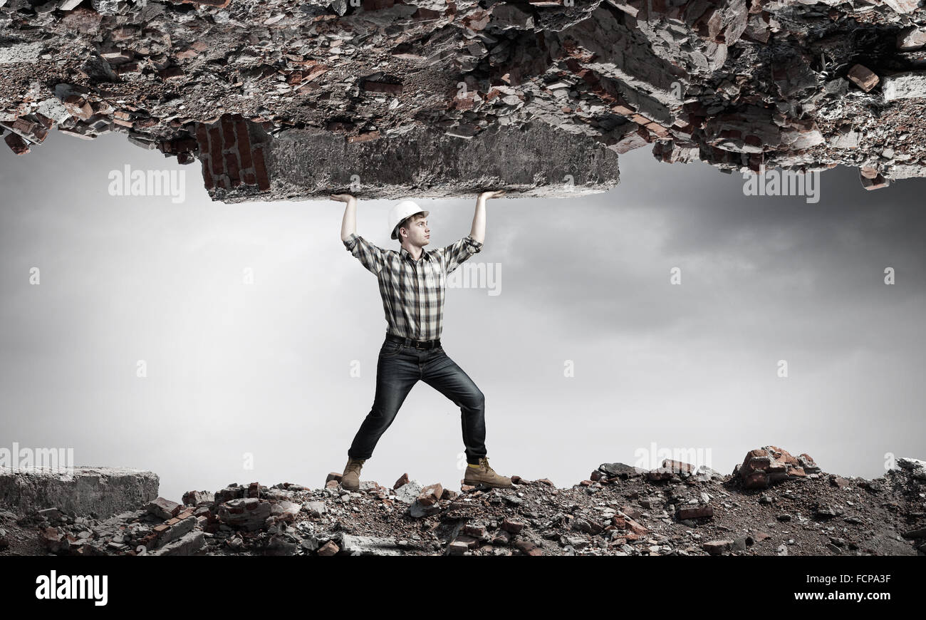 Strong man in uniform lifting wall above head Stock Photo - Alamy