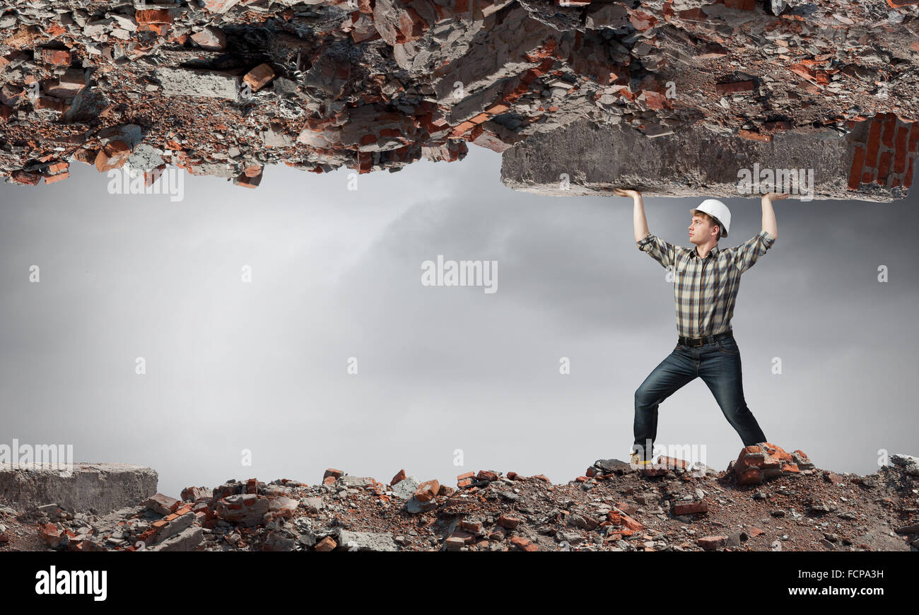 Strong man in uniform lifting wall above head Stock Photo - Alamy