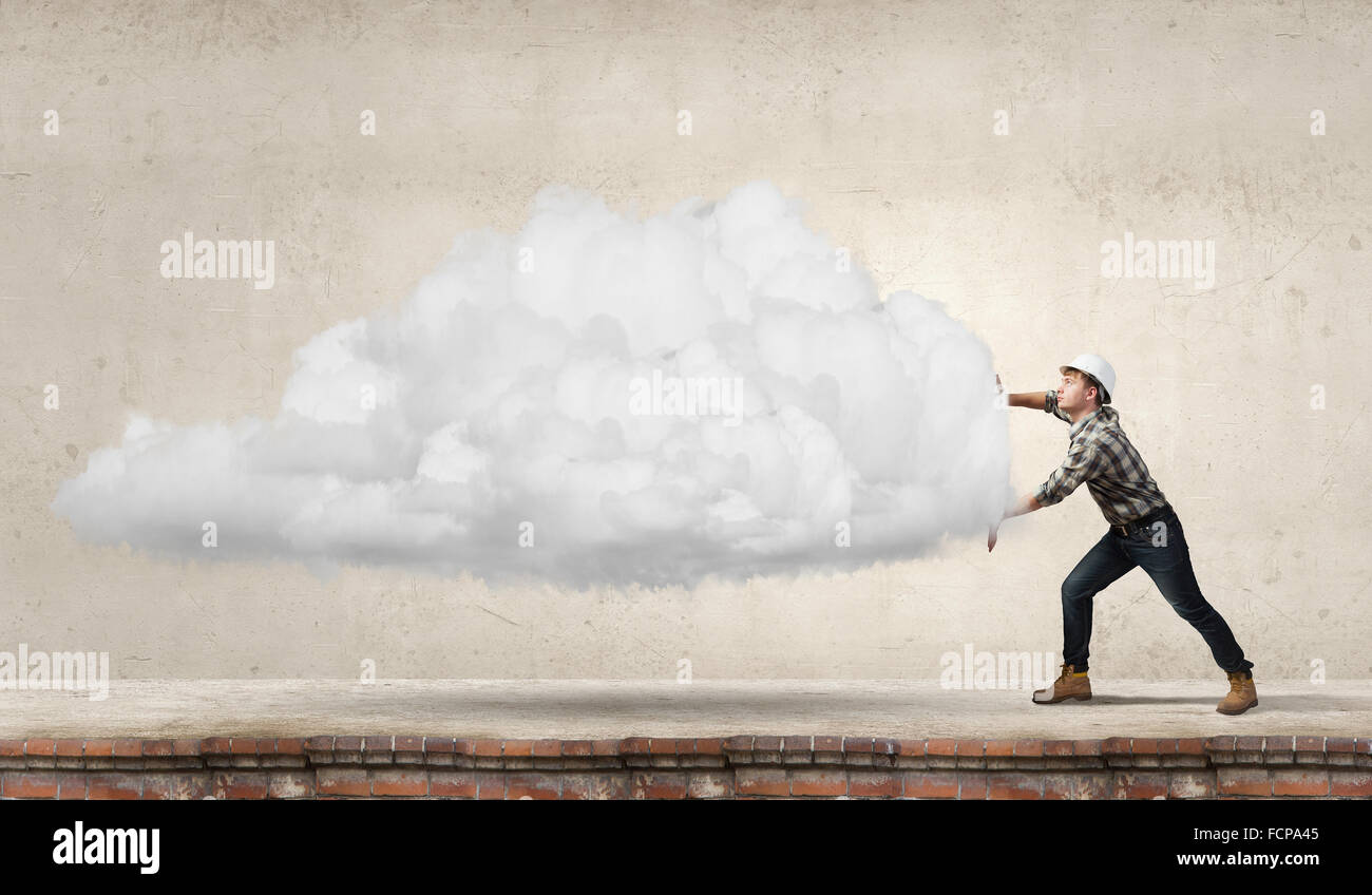 Young builder man moving big white cloud Stock Photo - Alamy