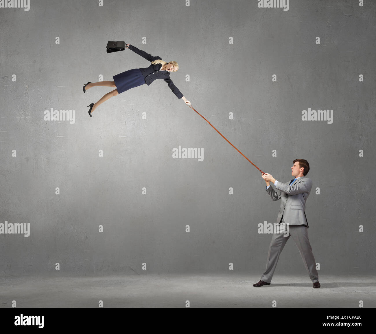 Young man on lead of colleague trying to escape Stock Photo - Alamy
