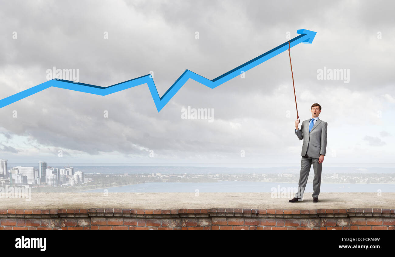 Young businessman caught increasing graph with lead Stock Photo - Alamy