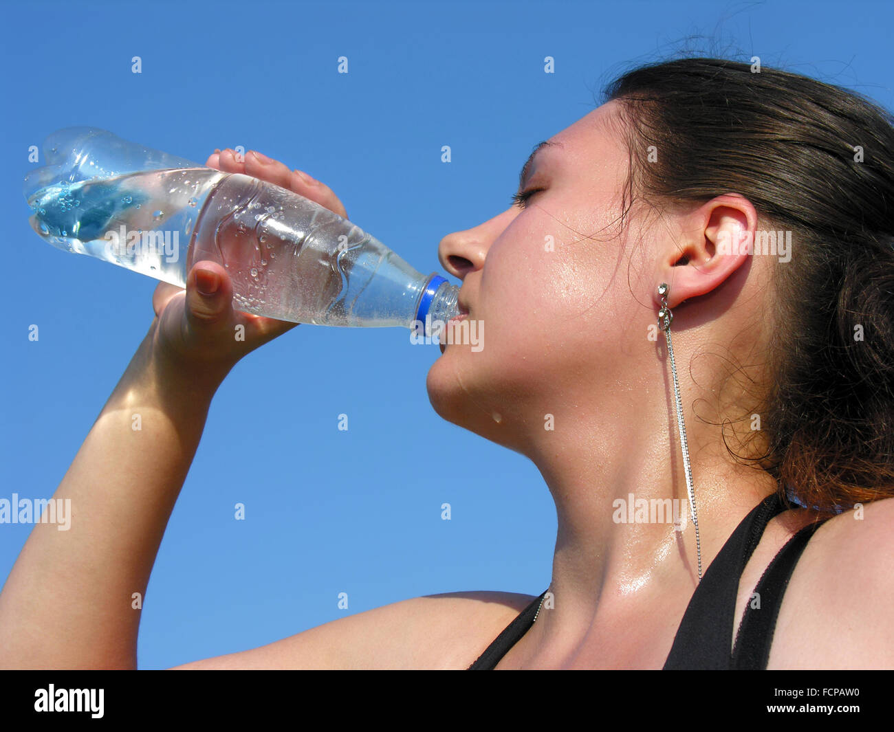 Thirst. Young woman drinking cold water in hot day Stock Photo - Alamy