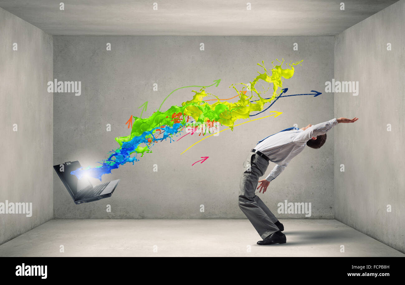 Balancing young man evading from explosion of ideas Stock Photo - Alamy
