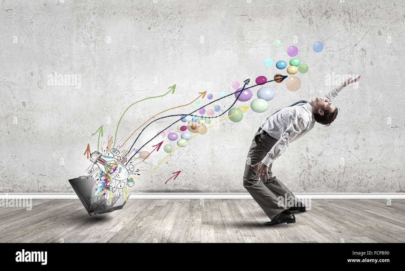 Balancing young man evading from explosion of ideas Stock Photo - Alamy
