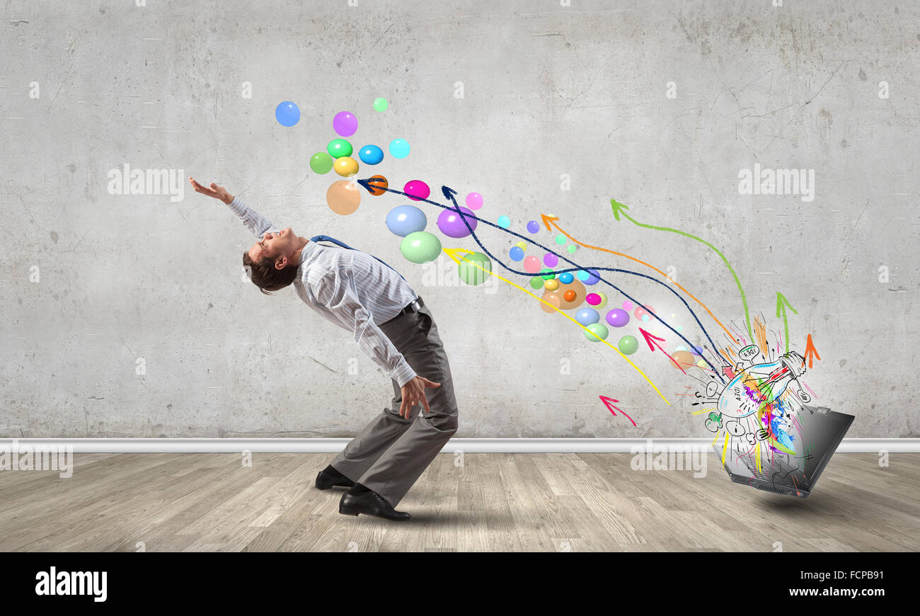Balancing young man evading from explosion of ideas Stock Photo - Alamy