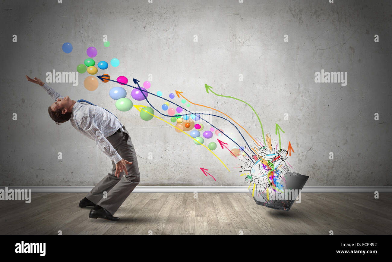 Balancing young man evading from explosion of ideas Stock Photo - Alamy