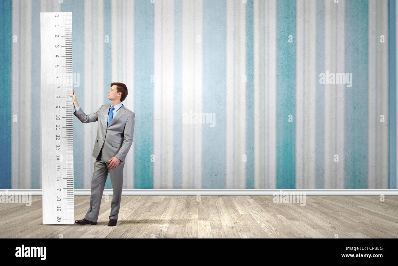 Young businessman in suit measuring ruler benefit Stock Photo - Alamy