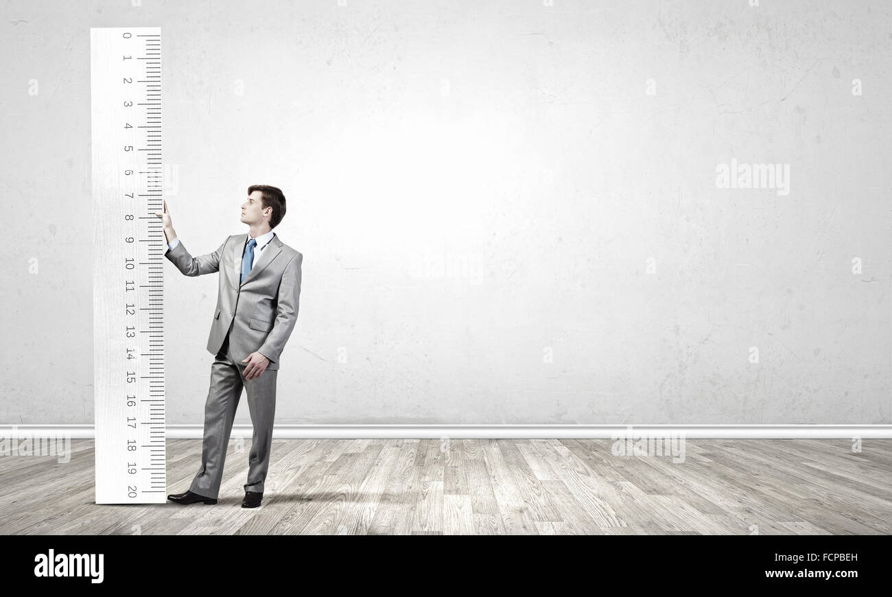 Young businessman in suit measuring ruler benefit Stock Photo - Alamy