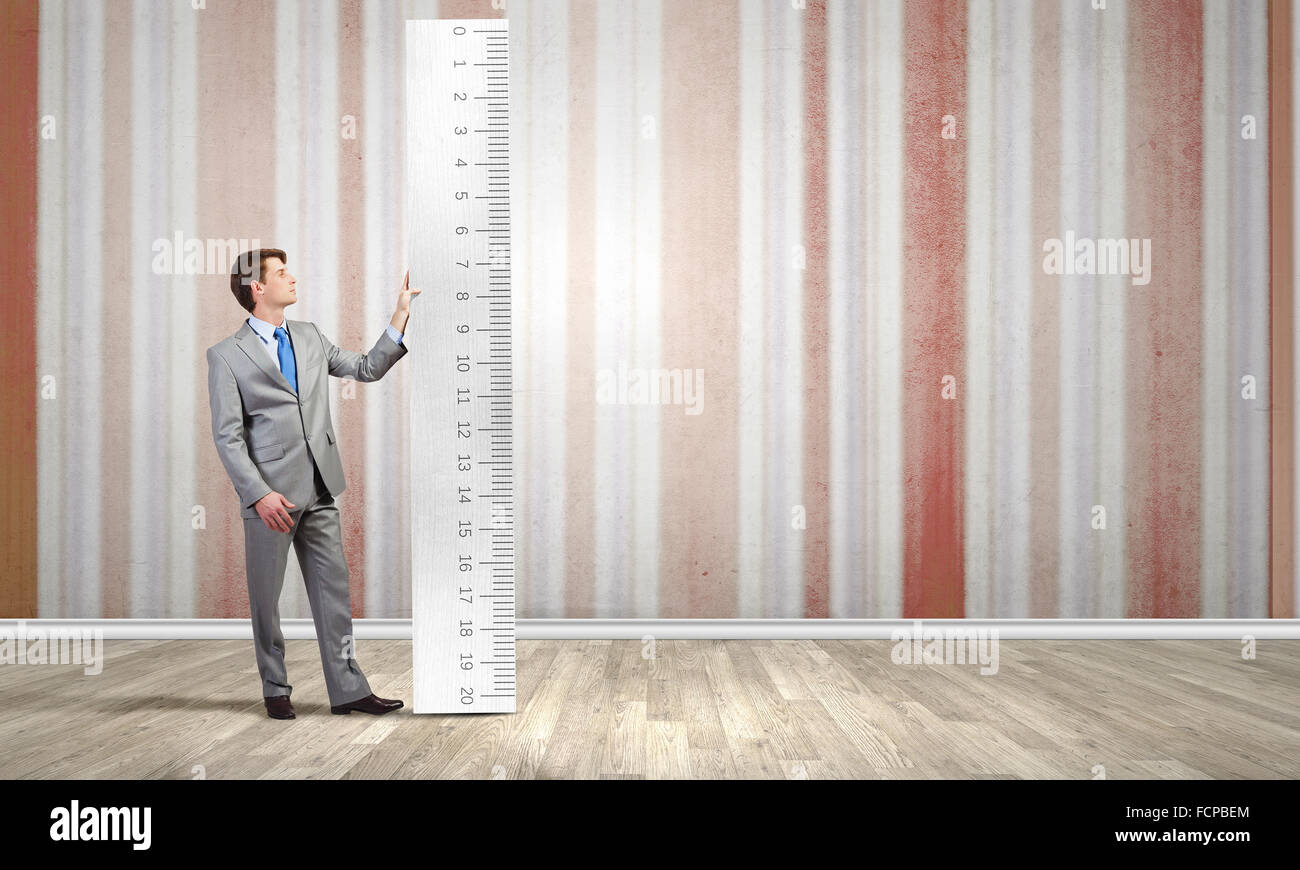 Young businessman in suit measuring ruler benefit Stock Photo - Alamy