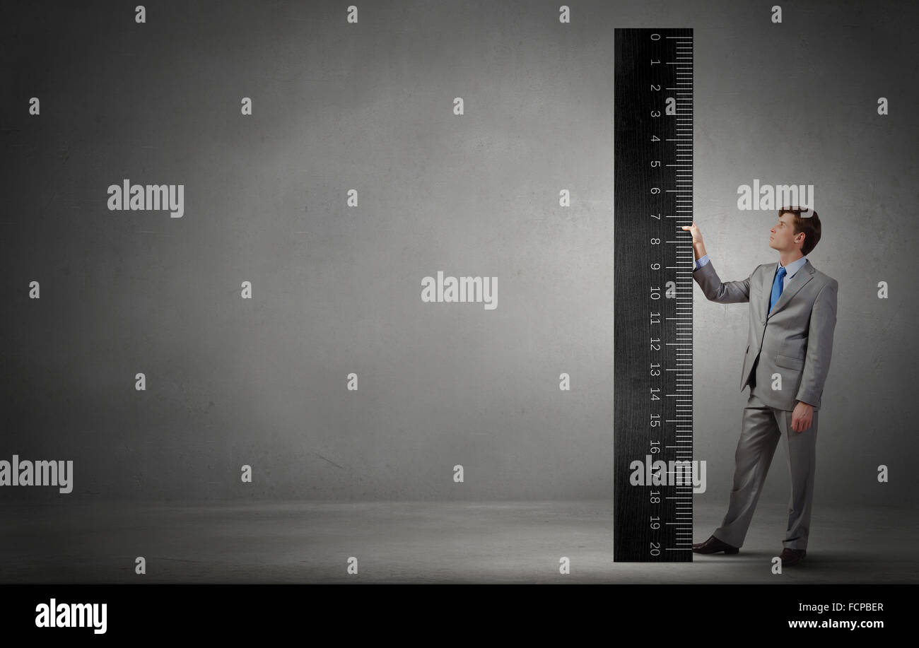 Young businessman in suit measuring ruler benefit Stock Photo - Alamy