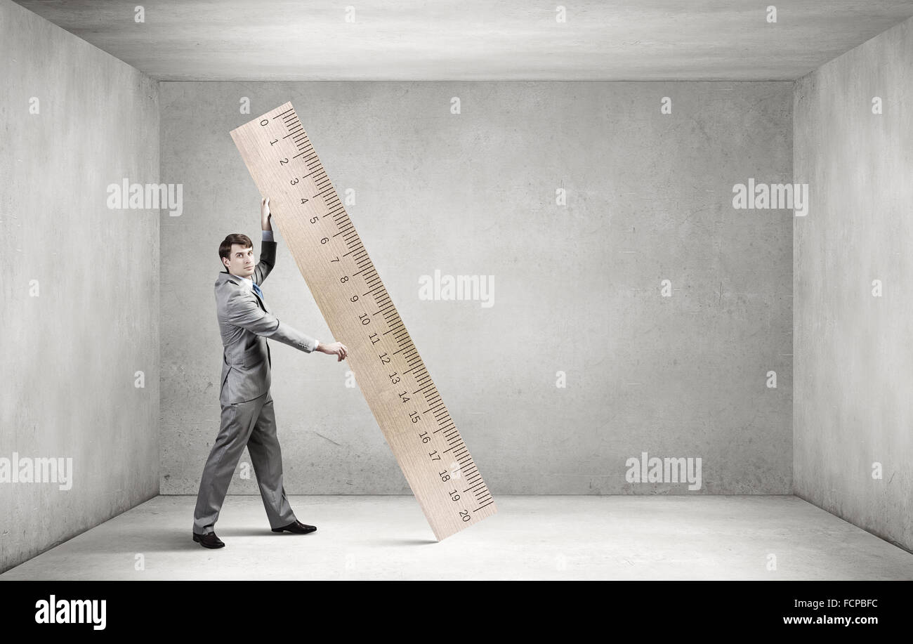 Young businessman in suit measuring ruler benefit Stock Photo - Alamy