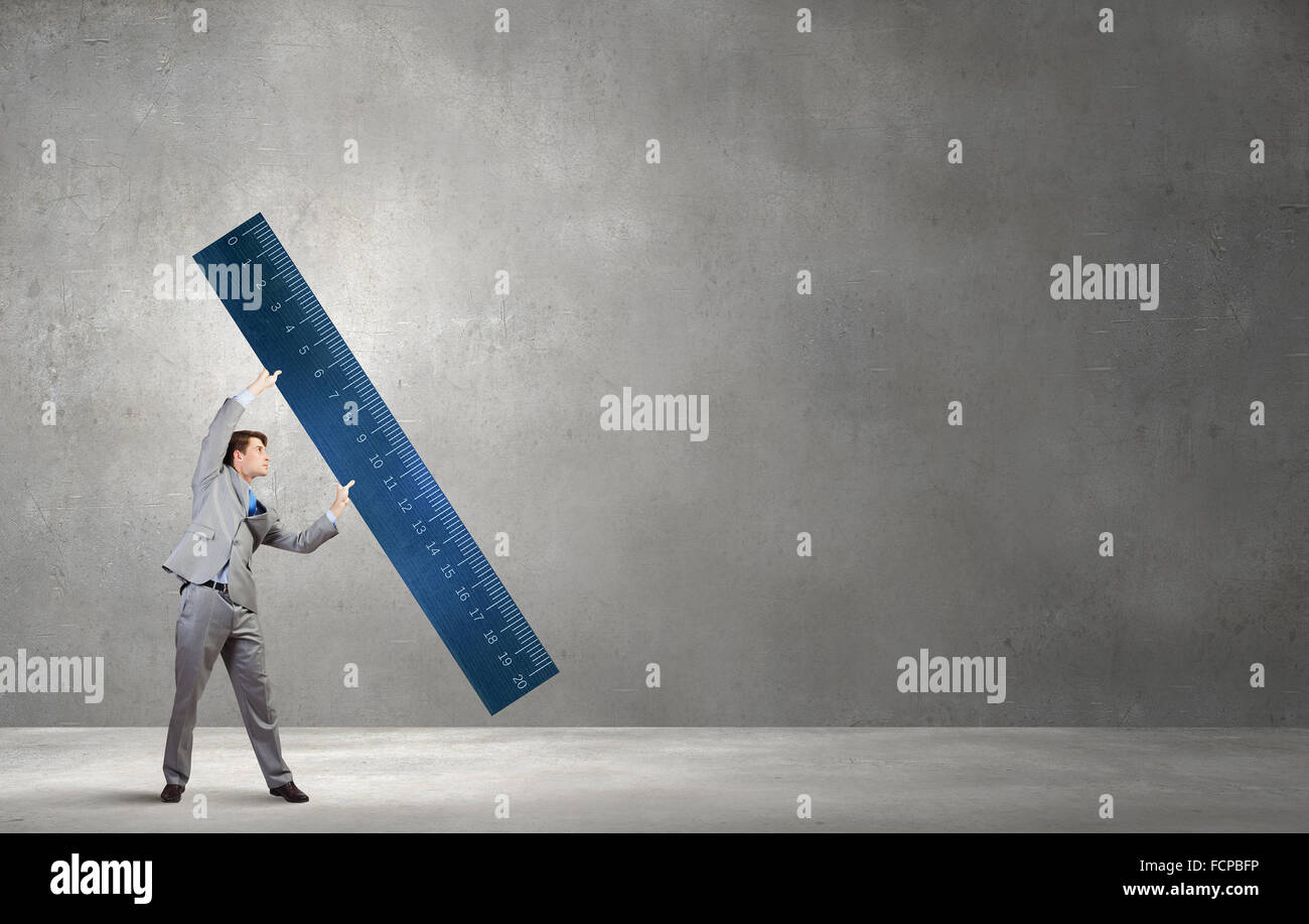 Young businessman in suit measuring ruler benefit Stock Photo - Alamy