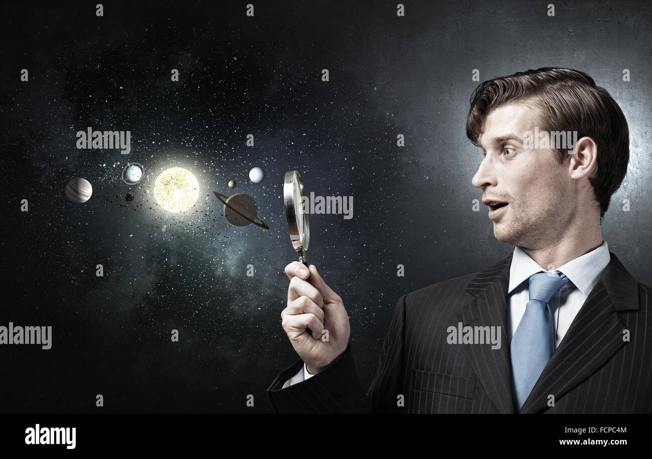 Young businessman exploring planets of sun system Stock Photo - Alamy