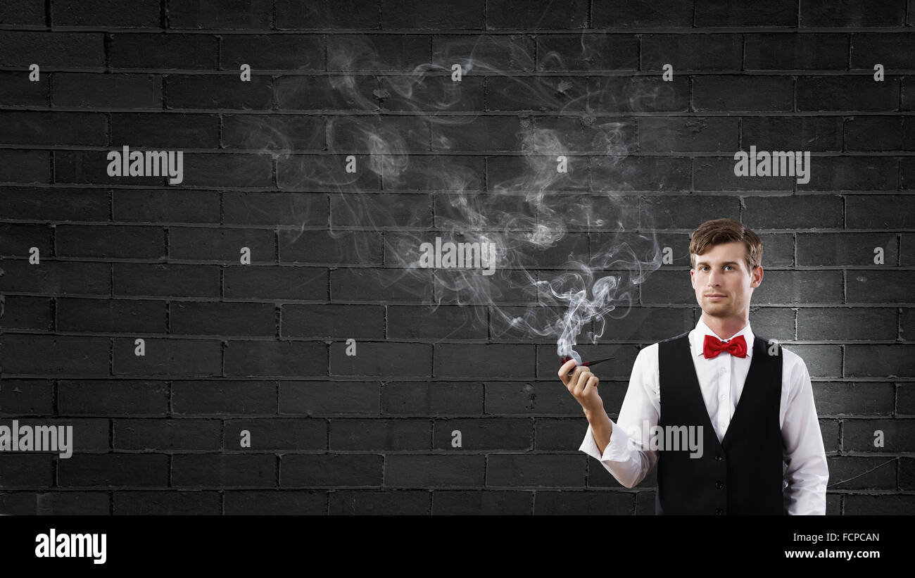 Handsome young businessman thinking over ideas and smoking pipe Stock ...