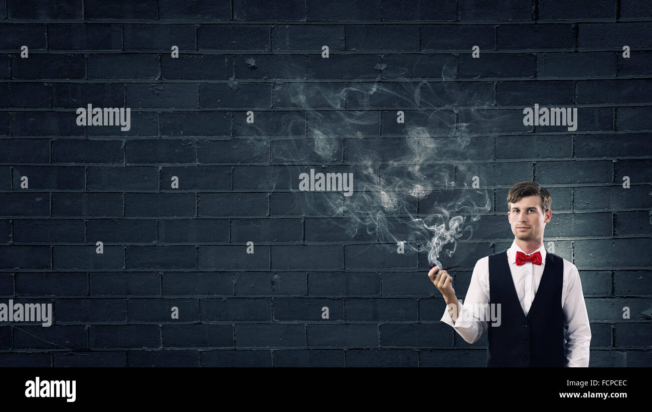 Handsome young businessman thinking over ideas and smoking pipe Stock ...