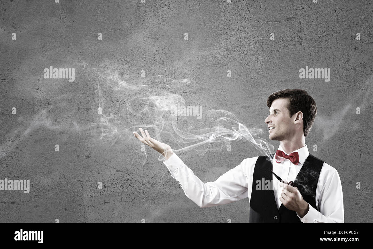 Handsome young businessman thinking over ideas and smoking pipe Stock ...