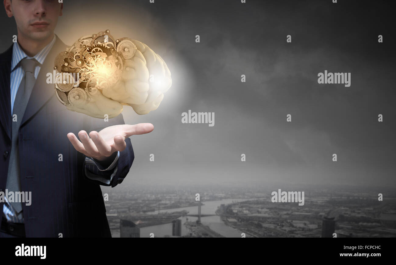Close up of businessman holding human brain with working gears Stock ...