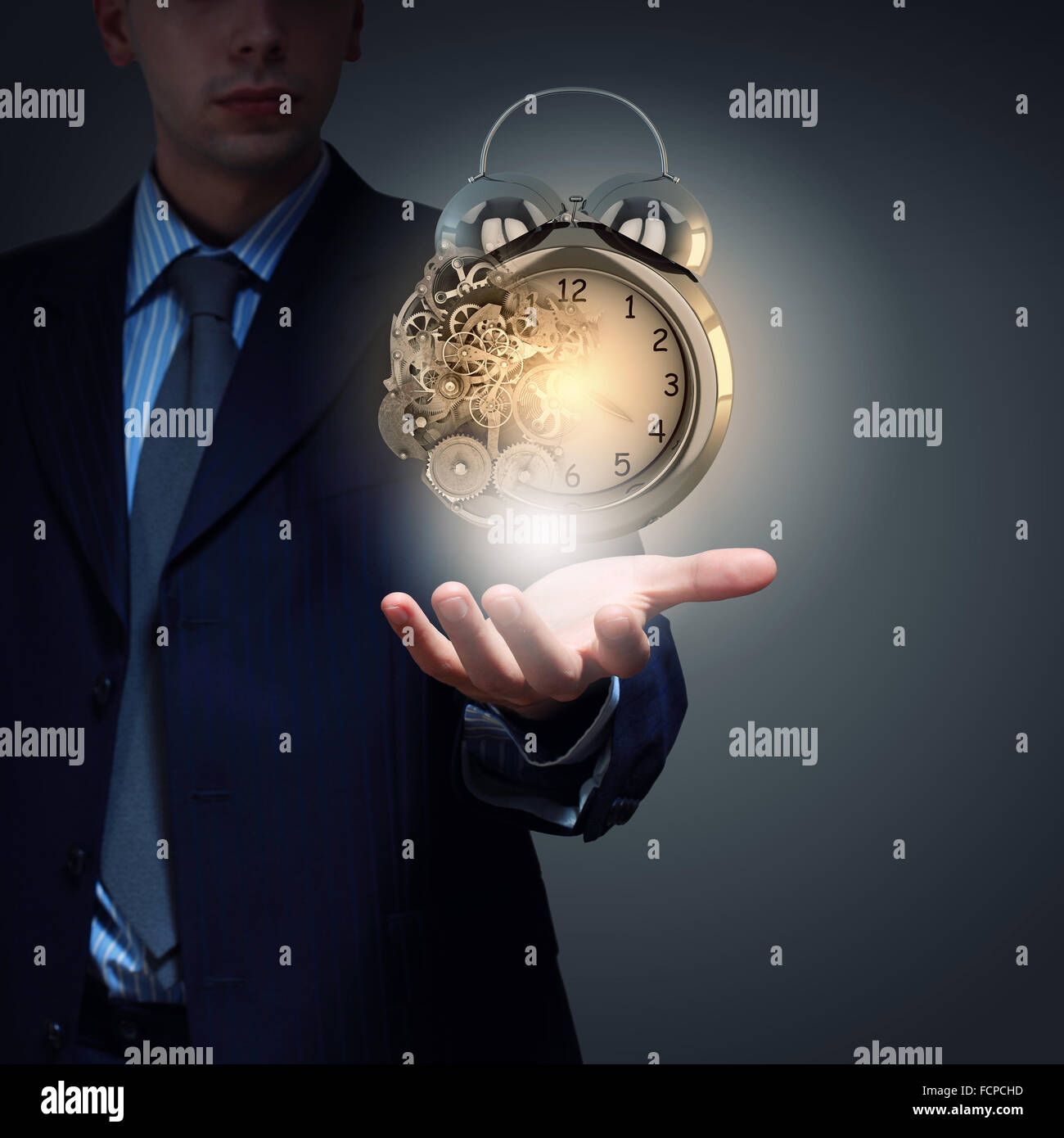 Close up of businessman hand holding old alarm clock Stock Photo - Alamy
