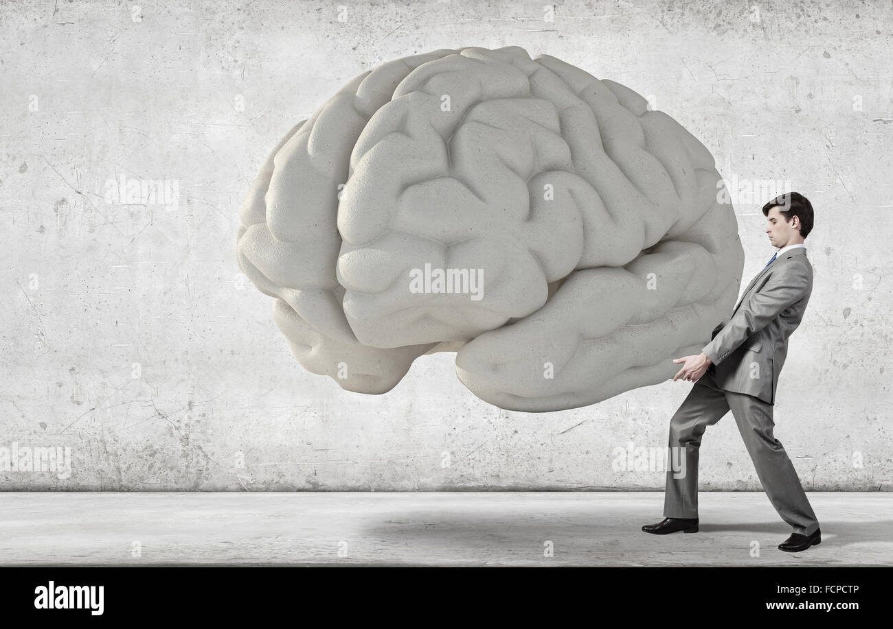 Businessman making effort to carry huge human brain Stock Photo - Alamy