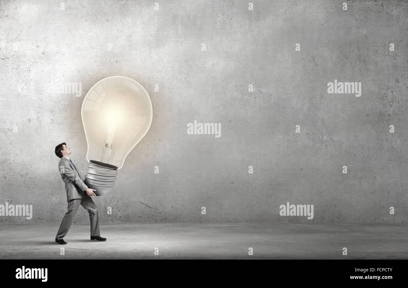 Young businessman carrying in hands big light bulb Stock Photo - Alamy