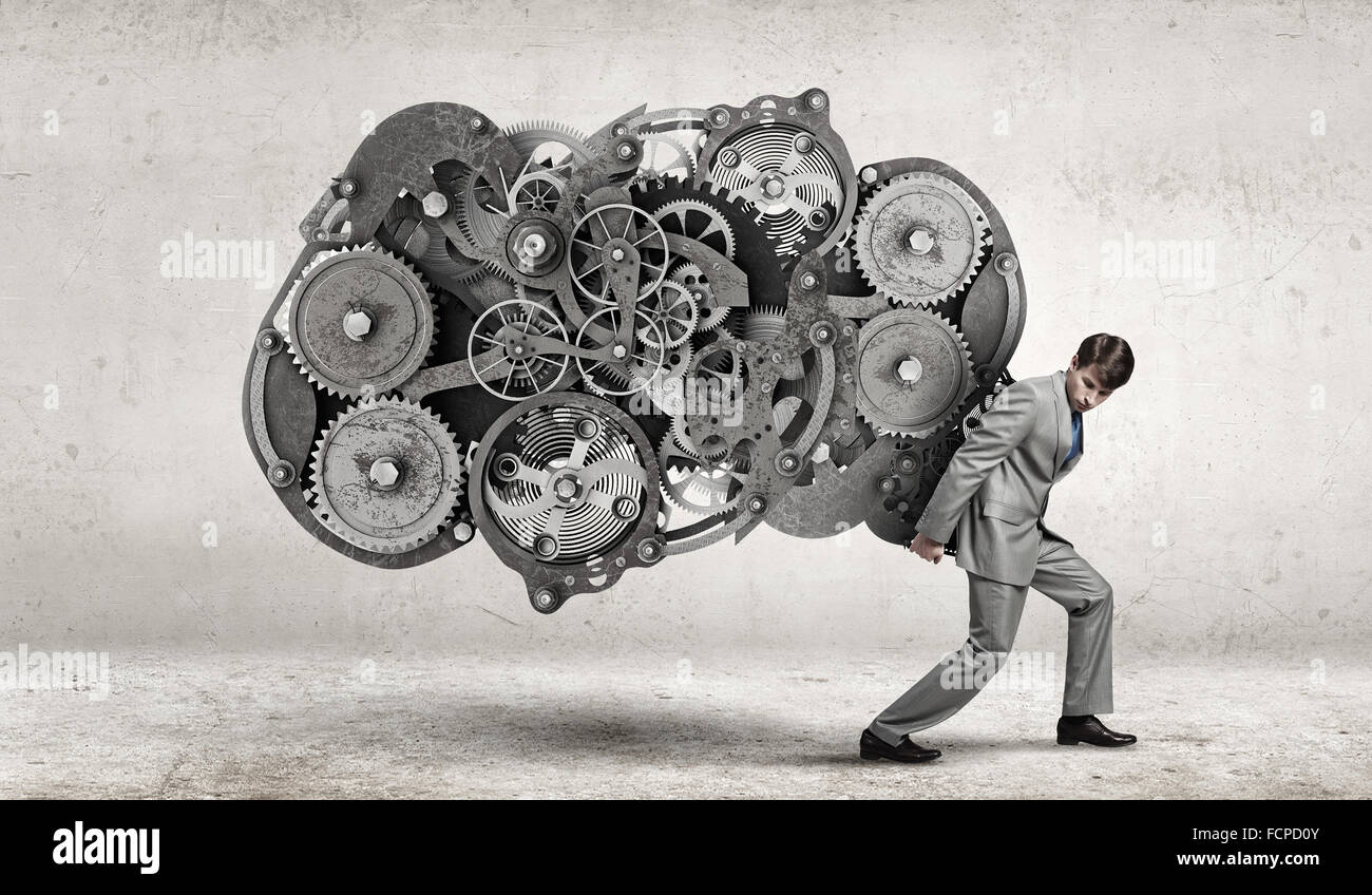 Young businessman carrying huge gears mechanism on back hi-res stock ...