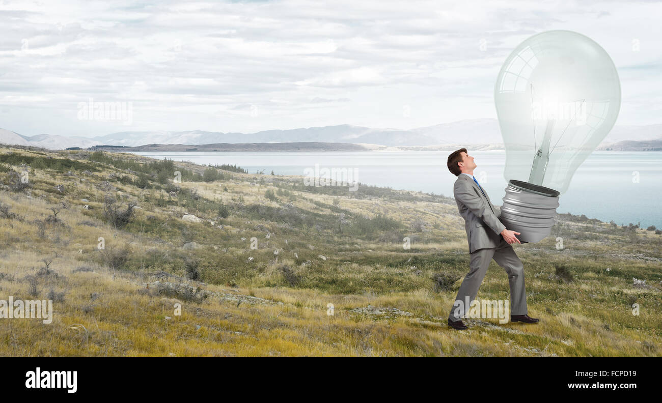 Young businessman carrying in hands big light bulb Stock Photo - Alamy