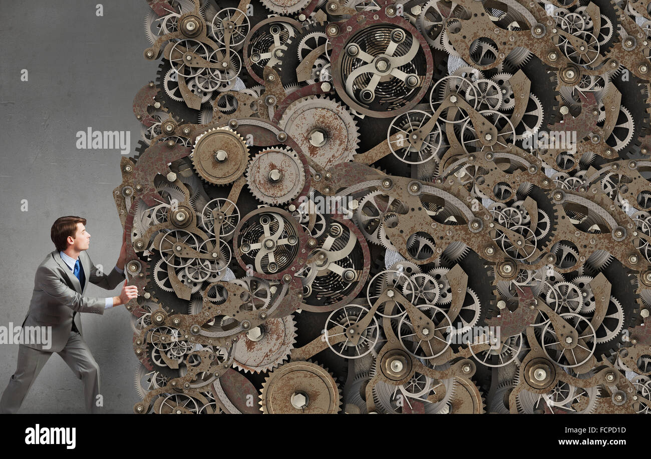 Young businessman carrying huge gears mechanism on back Stock Photo - Alamy