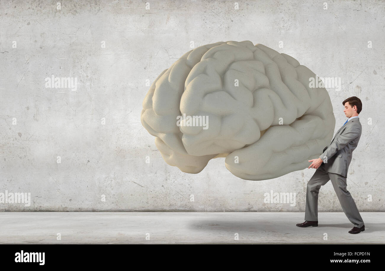 Businessman making effort to carry huge human brain Stock Photo - Alamy