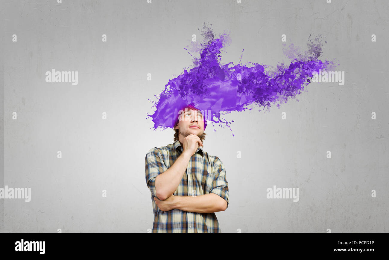 Thoughtful young man with colorful splashes out of his head Stock Photo ...