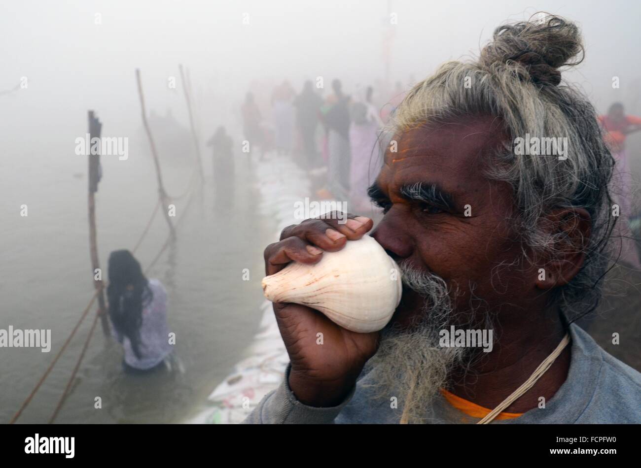 Allahabad, India. 24th Jan, 2016. A Sadhu blowing conch shell after ...