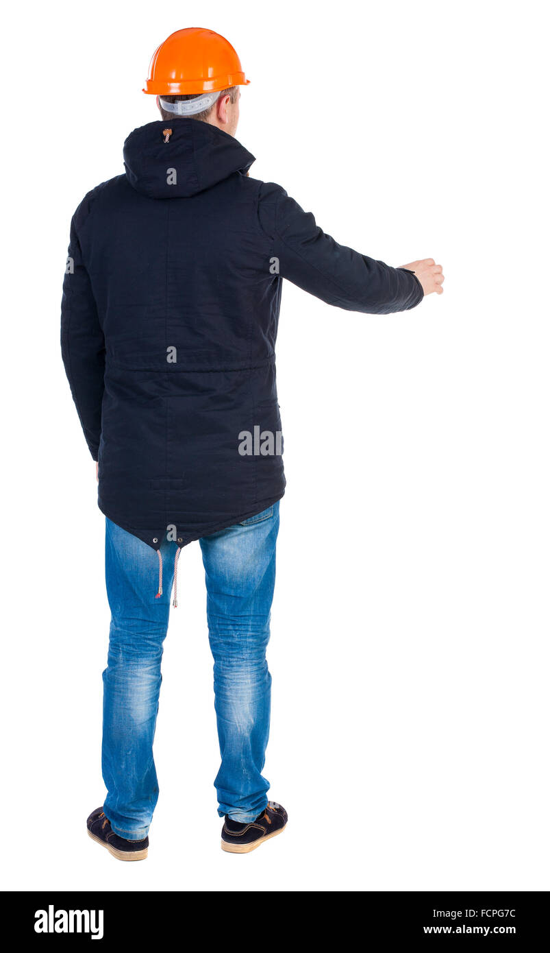 Back view of an engineer in construction helmet stands. Standing young ...