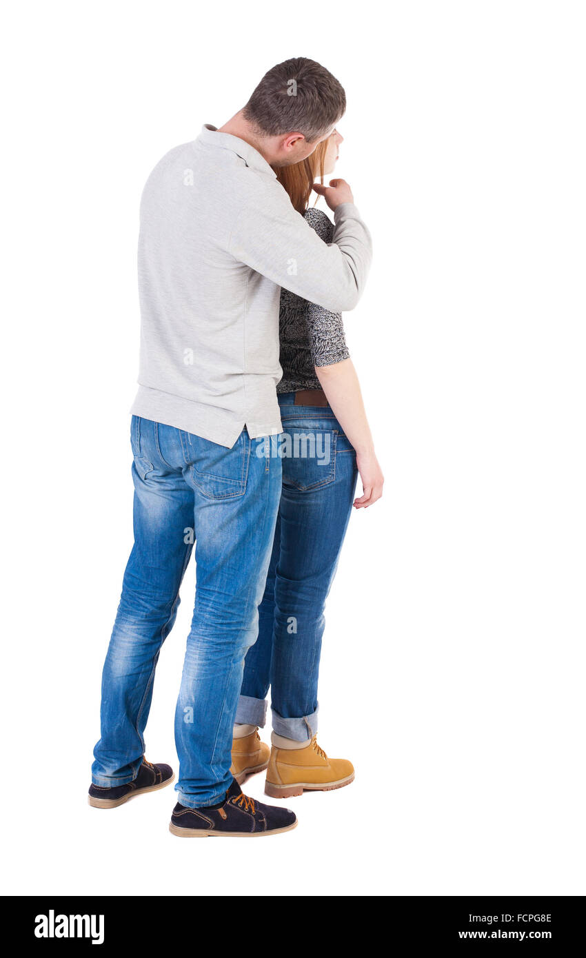 Back view of young embracing couple (man and woman) hug and look into ...