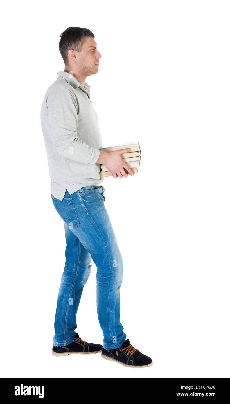 Back view of going handsome man carries a stack of books. walking young ...
