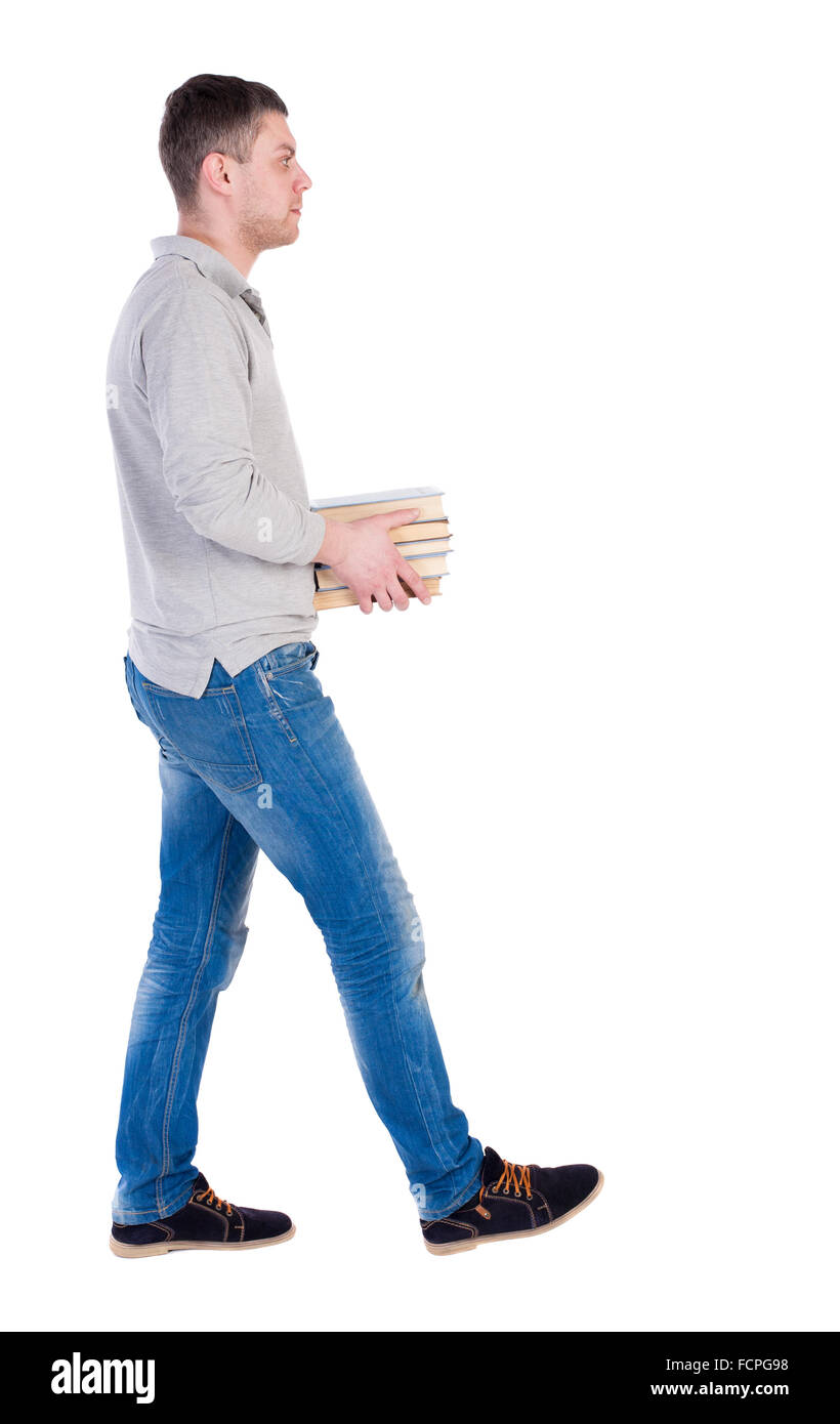Back view of going handsome man carries a stack of books. walking young ...