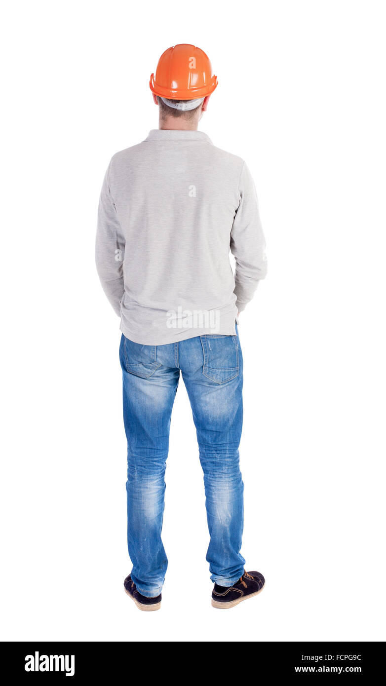 Backview of an engineer in construction helmet stands. Standing young ...