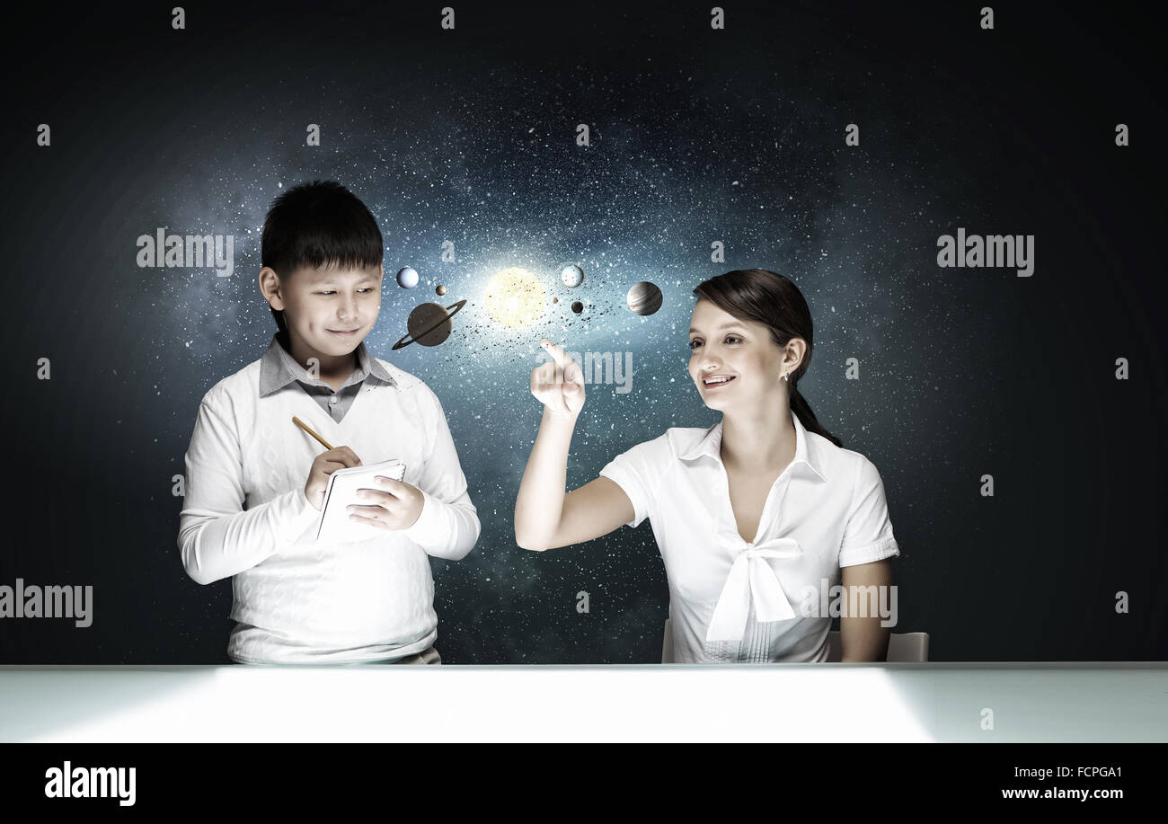 Cute boy of school age and teacher exploring space system Stock Photo ...