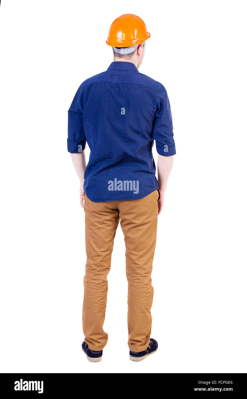 Backview of an engineer in construction helmet stands. Standing young ...