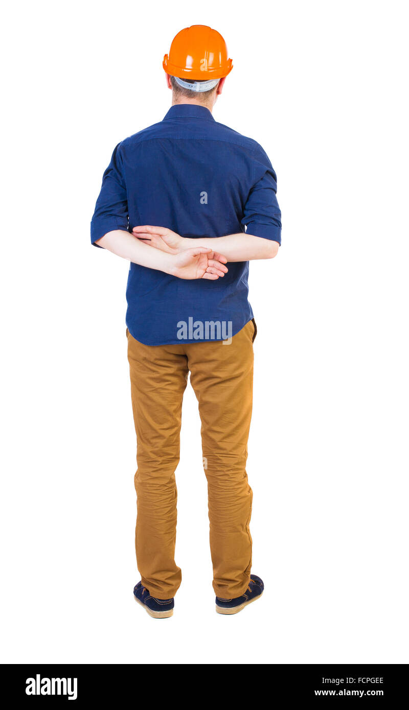 Backview of an engineer in construction helmet stands. Standing young ...