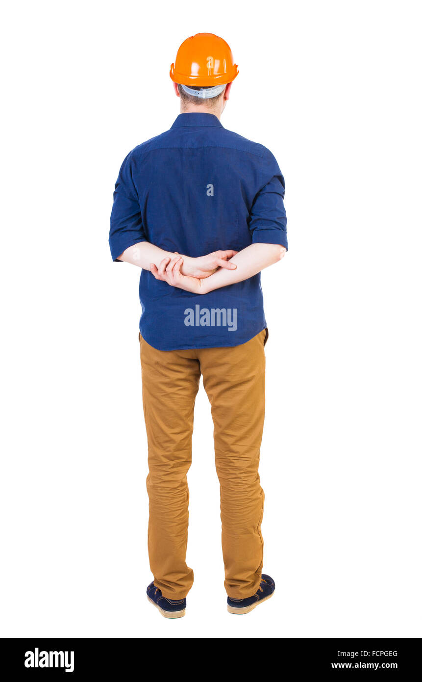 Backview of an engineer in construction helmet stands. Standing young ...