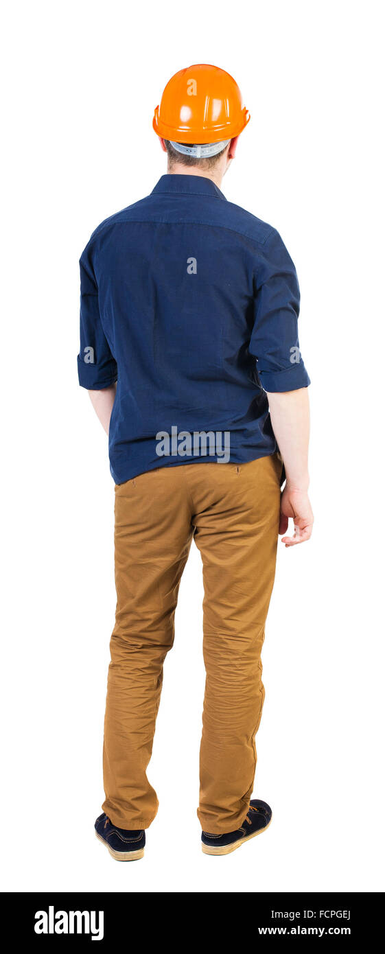 Backview of an engineer in construction helmet stands. Standing young ...